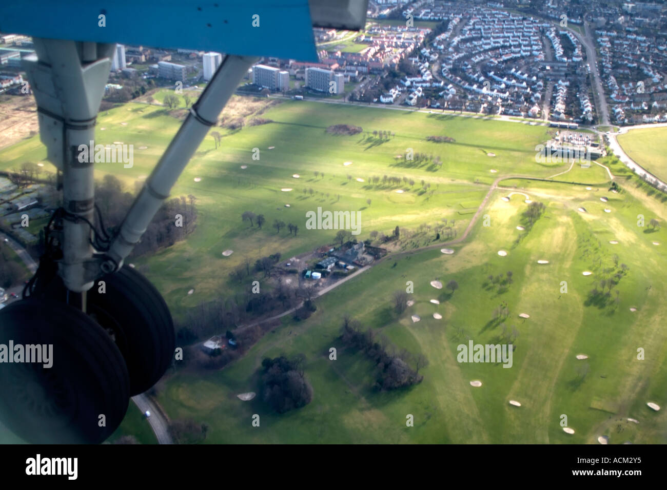 The wheels are lowered and ready to land on a small airplane flying ...