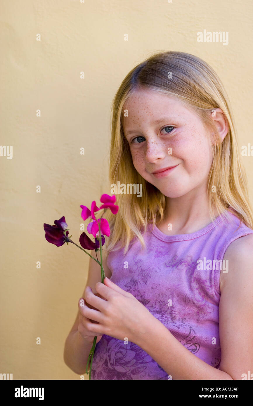 Portrait of blond blue eyed girl age 9 with freckles smiling while ...