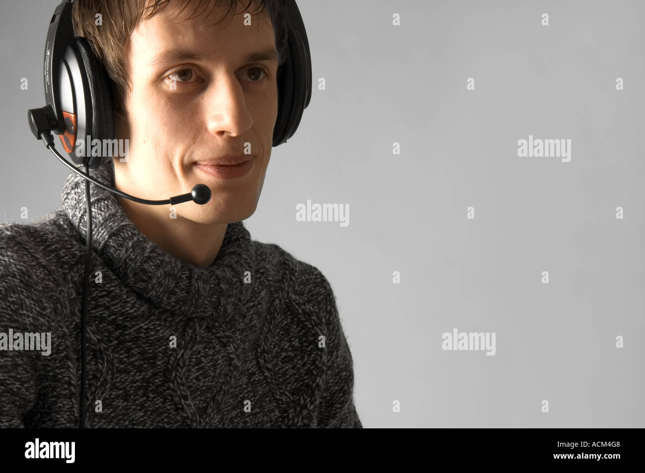 Man wearing headphones in computer room typing and smiling Stock Photo ...