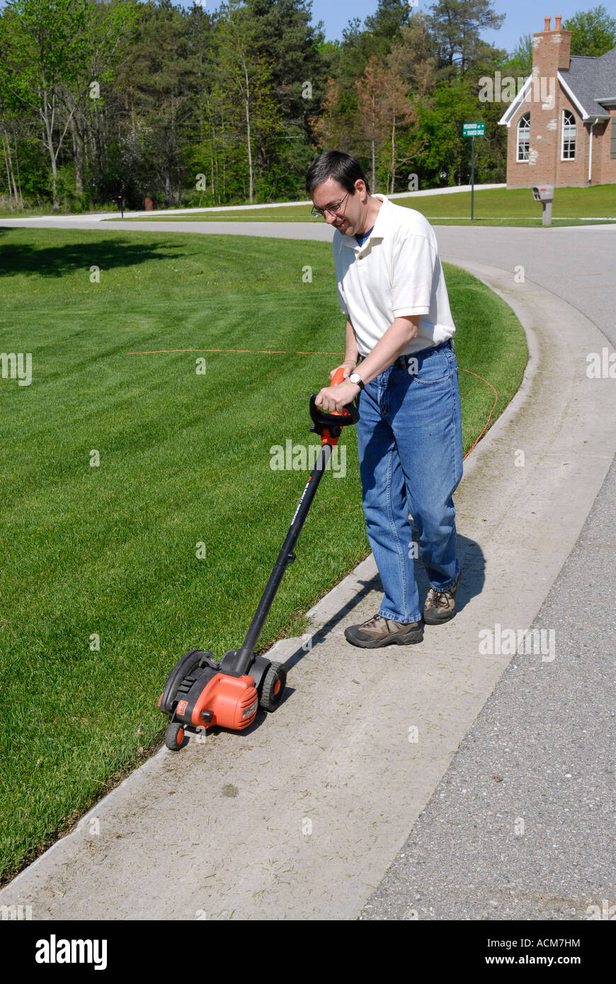 Edging driveway after mowing the lawn Stock Photo - Alamy