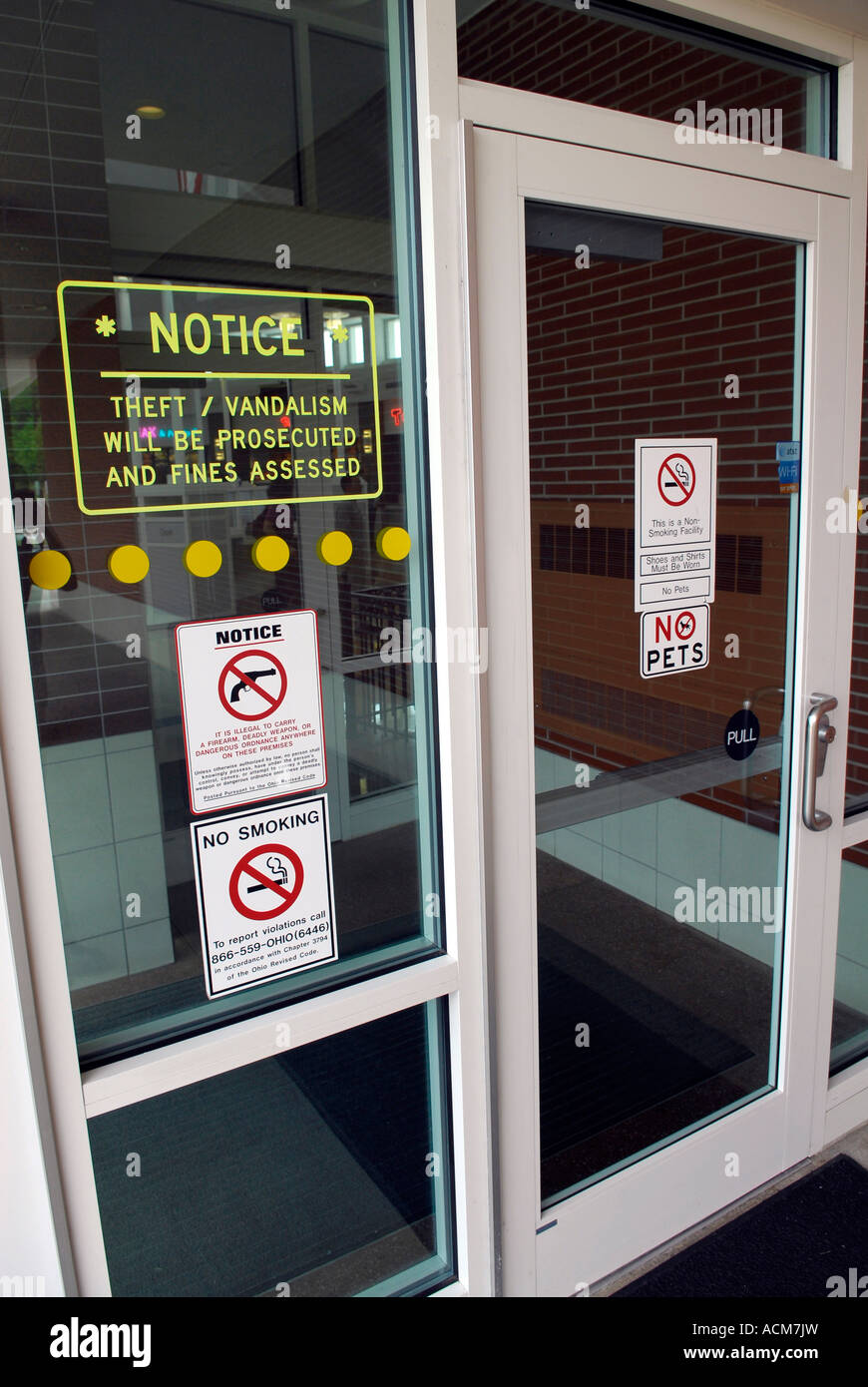 Signs on door prohibiting firearms guns weapons no smoking Stock Photo ...