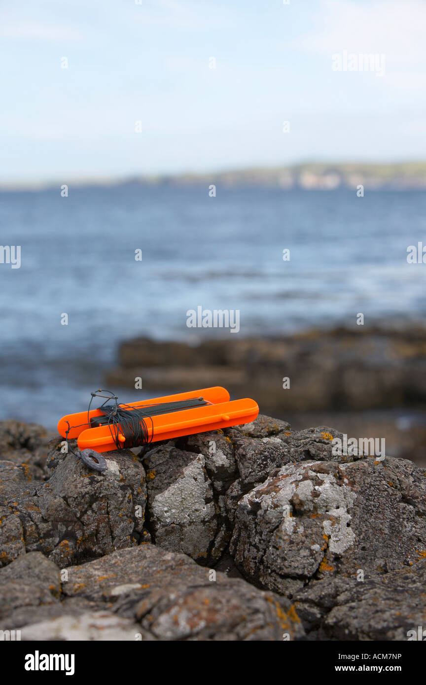 childrens bright orange crab line fishing line with weight sitting on ...