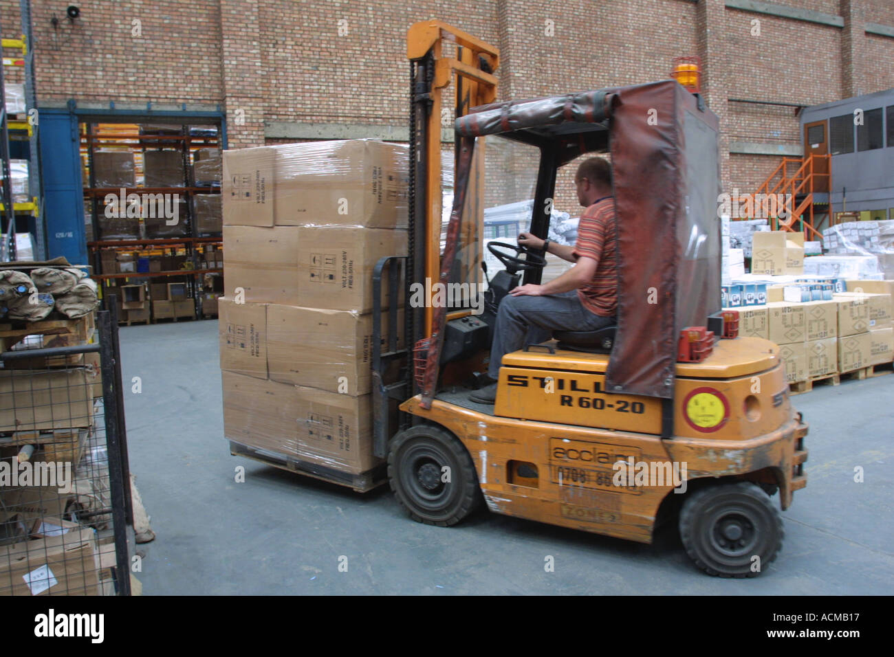 Fork lift with driver at work in warehouse Stock Photo - Alamy