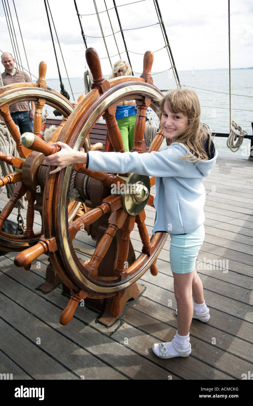 Eight year-old girl playing at the helm of the Grand Turk sailing ship ...