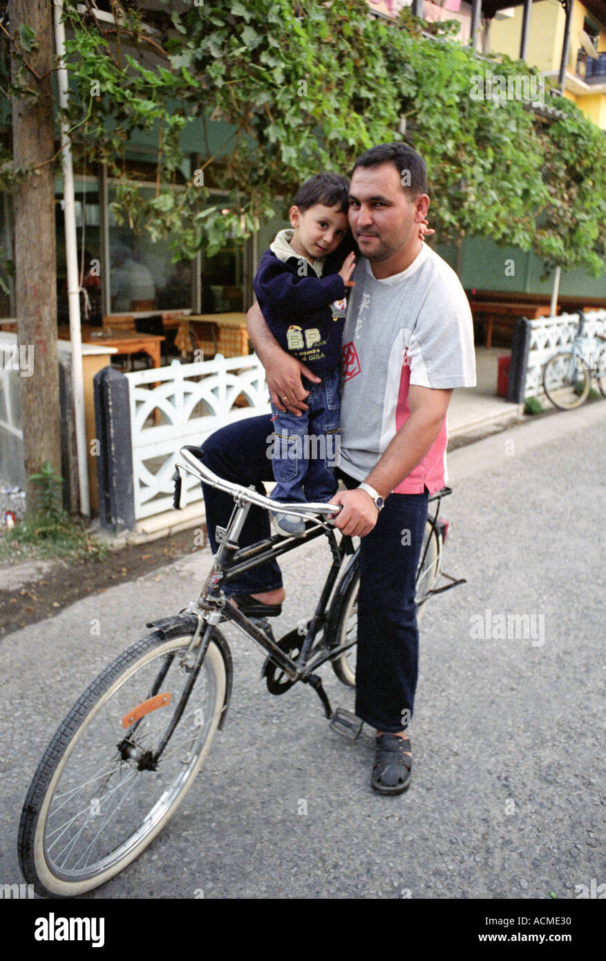 Turkish father and son on bicycle on way home from school in small ...