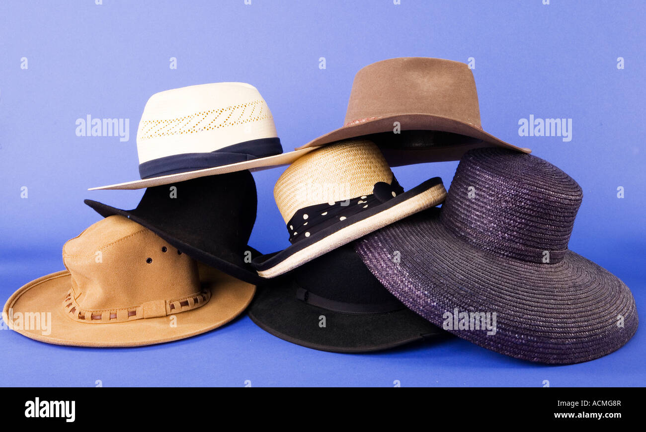 stack of different styles of hats on a blue background Stock Photo - Alamy