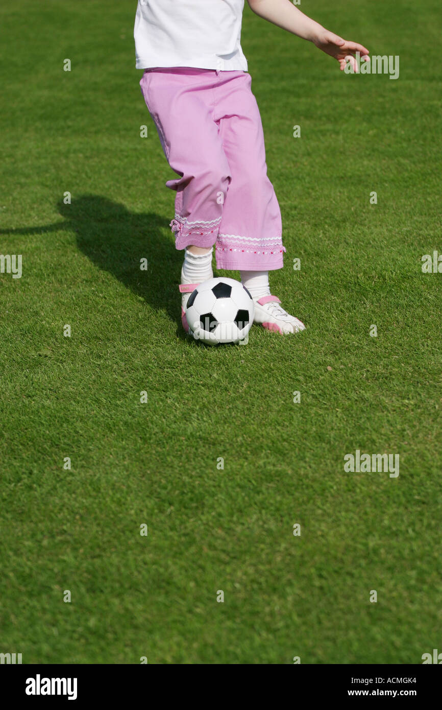 Young girl running around park playing football in the summer sun Stock ...