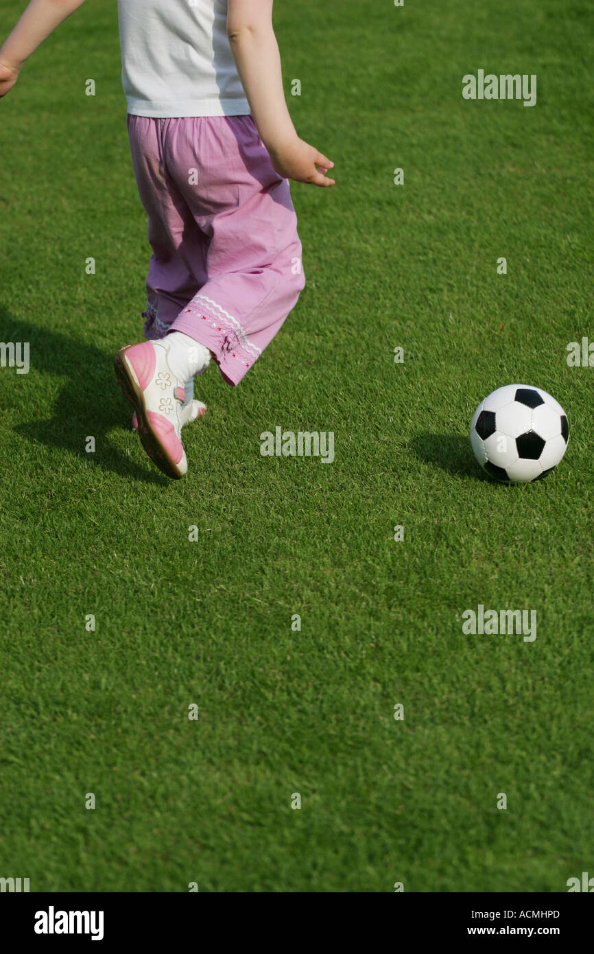 Young girl, running and playing football on grass Stock Photo - Alamy