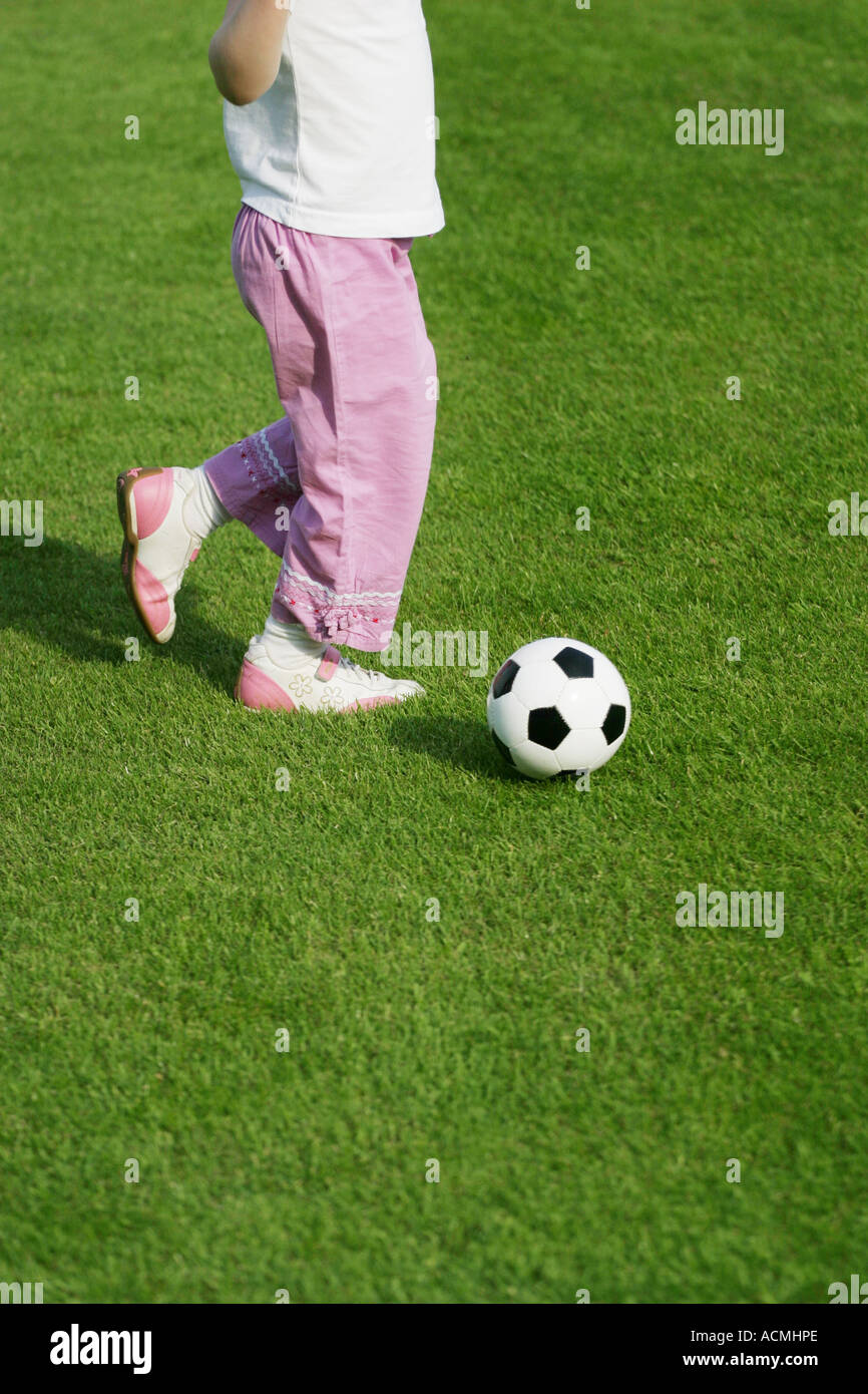 Young girl, running and playing football on grass Stock Photo - Alamy
