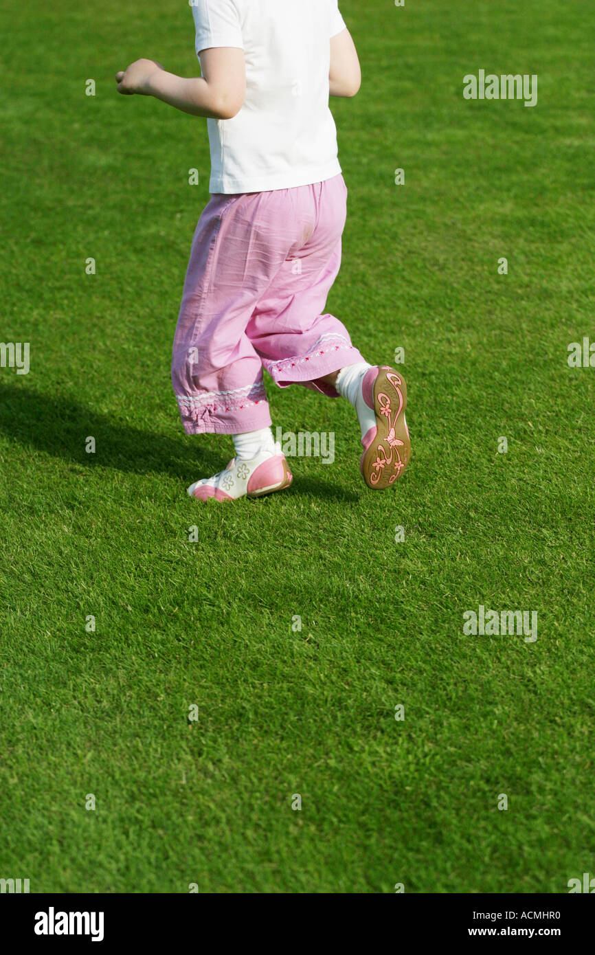 Young girl, running and playing football on grass Stock Photo - Alamy