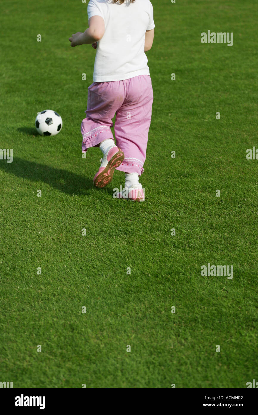 Young girl, running and playing football on grass Stock Photo - Alamy