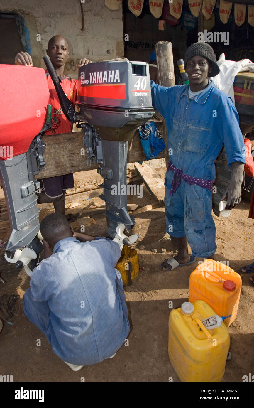 Young men repair fishing boat outboard motors at workshop Tanji Beach ...