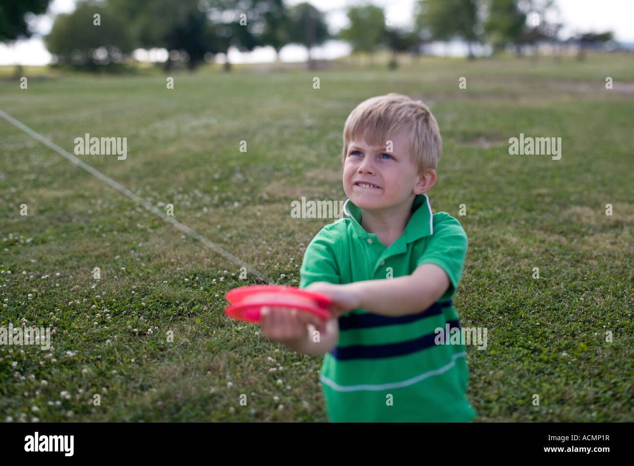 Child flying a kite holding string and looking up towards sky Stock ...