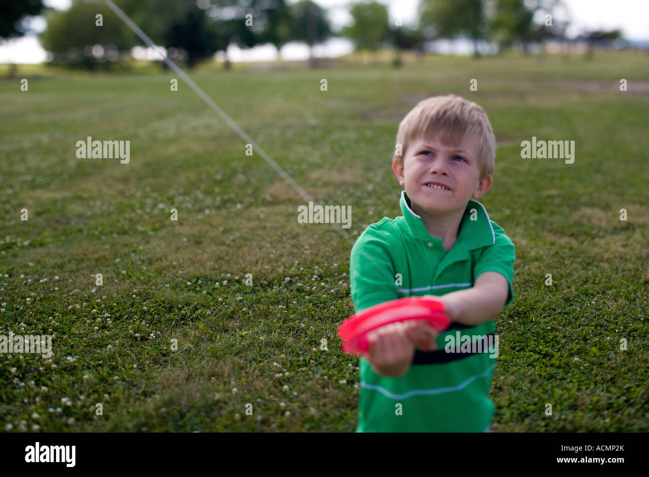 Child flying a kite holding string and looking up towards sky Stock ...
