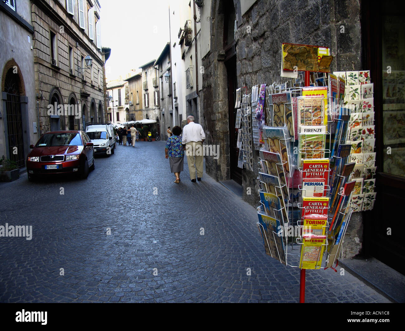 Italian maps in rack outside shop and couple walking down Corso Cavour ...