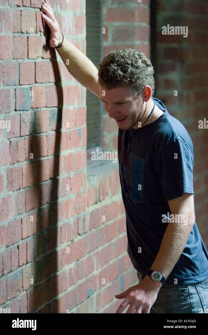 young male man teenager hitting punching punch hit brick wall portrait ...