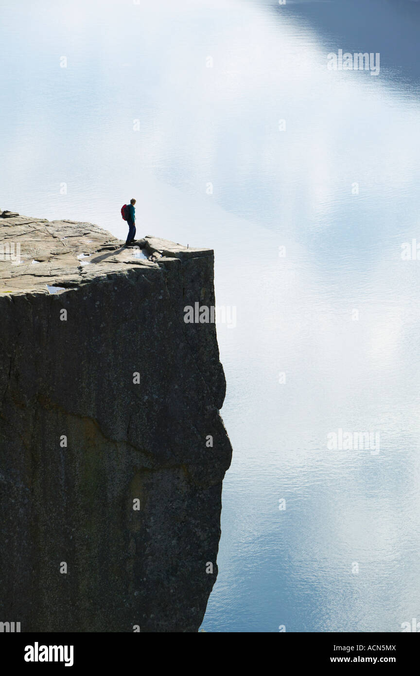Walker standing on Preikestolen, or Pulpit Rock, above Lysefjorden ...