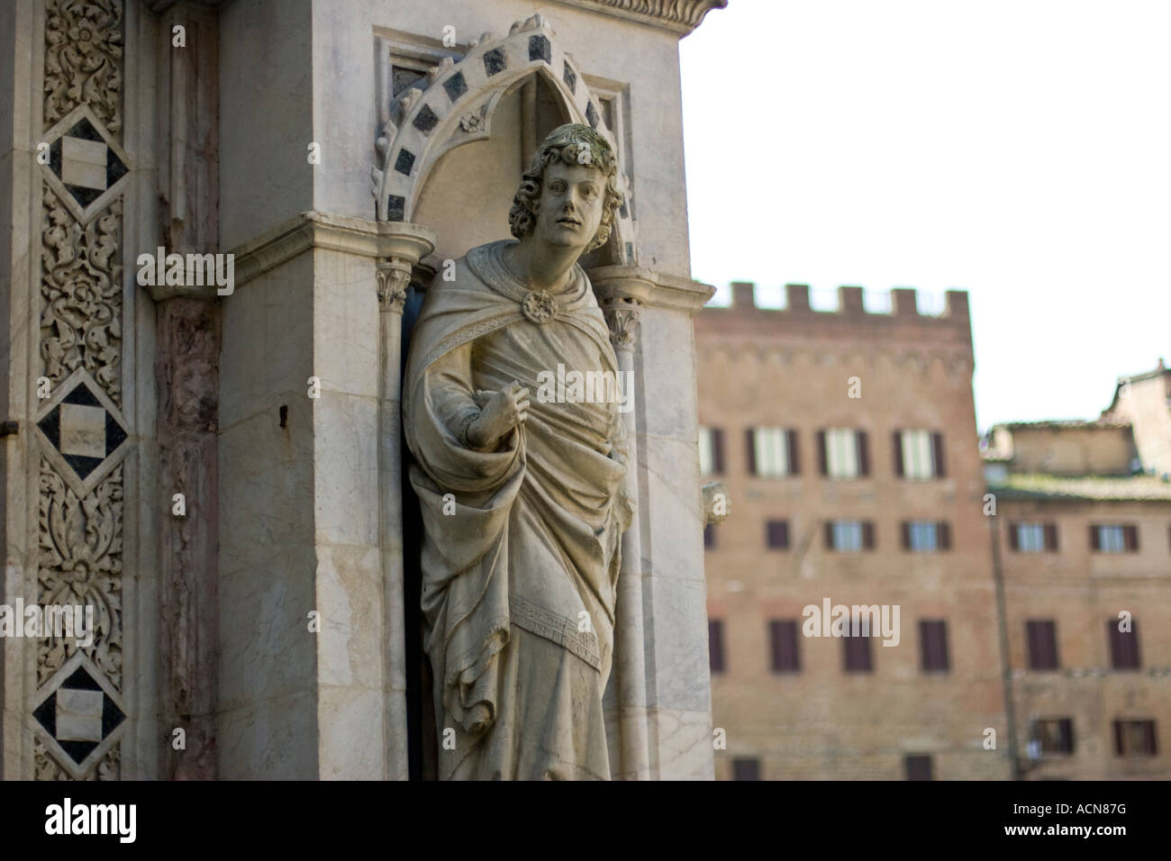 Statue on the side of a building in Siena, Tuscany, Italy Stock Photo ...