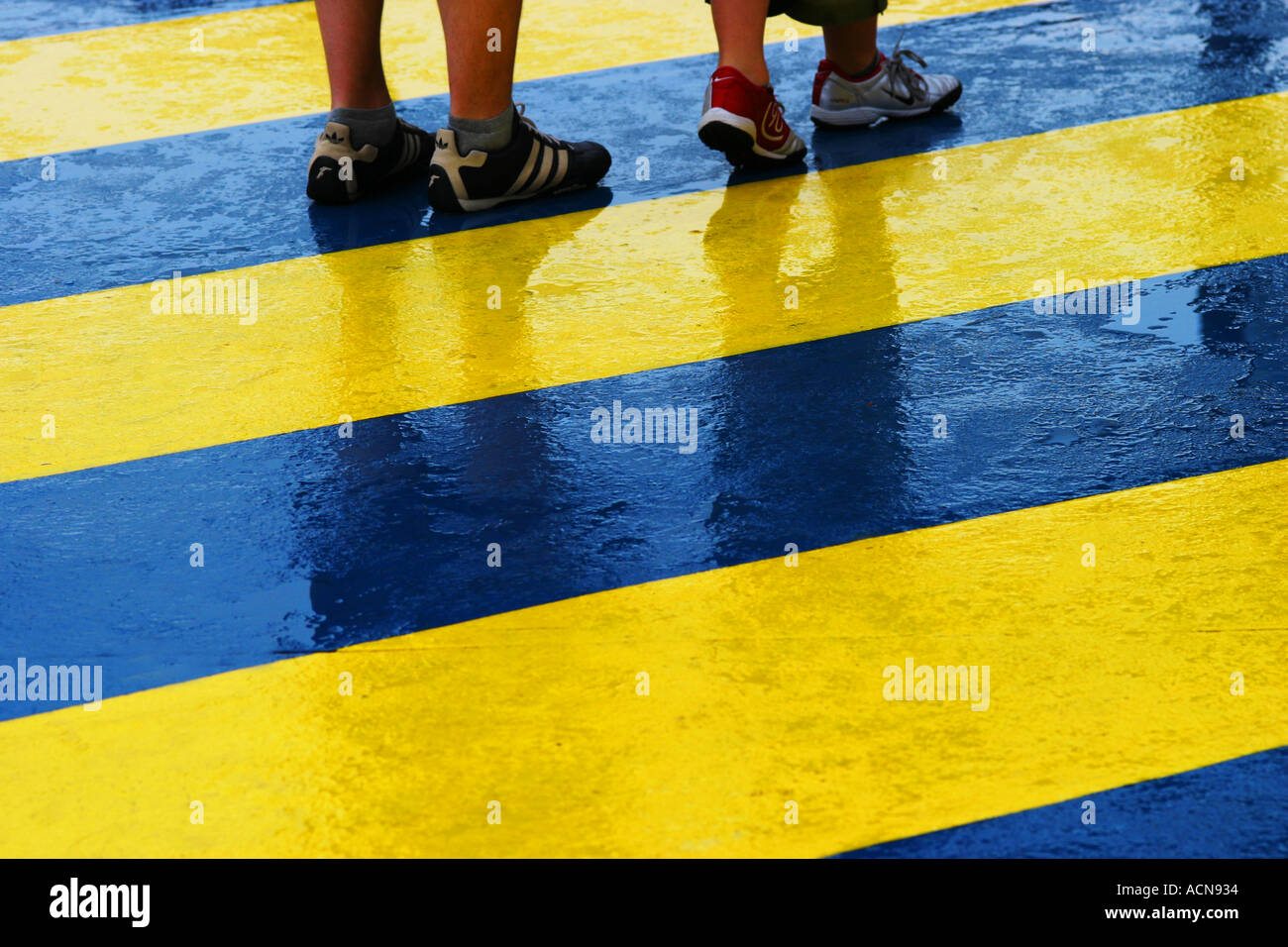yello and blue striped crossing with shot of feet walking across Stock ...