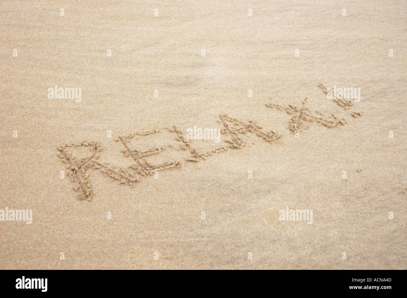 Word relax written in sand on beach Stock Photo - Alamy