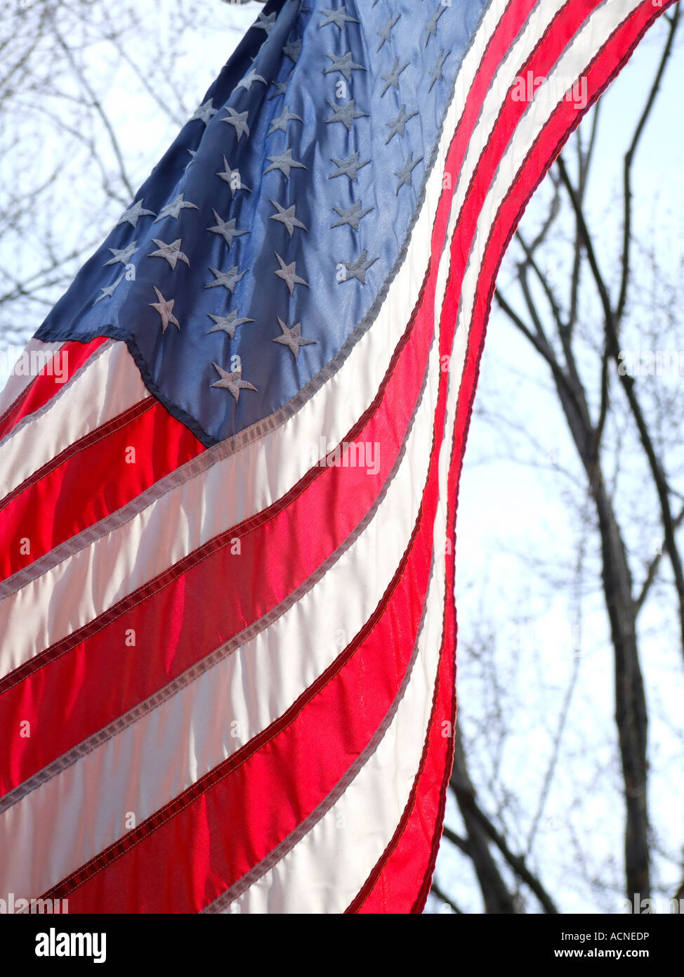 American flag blowing in the wind as the sun sets on an early spring ...