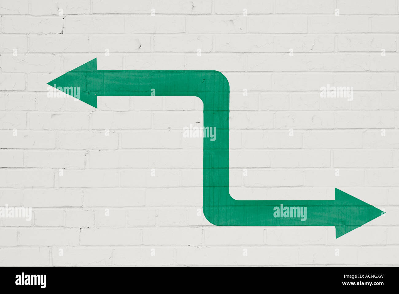 Bi-directional arrow painted on white brick wall Stock Photo - Alamy