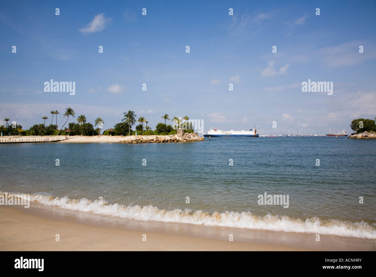 sheltered tropical Siloso beach and bay with man made island at western ...