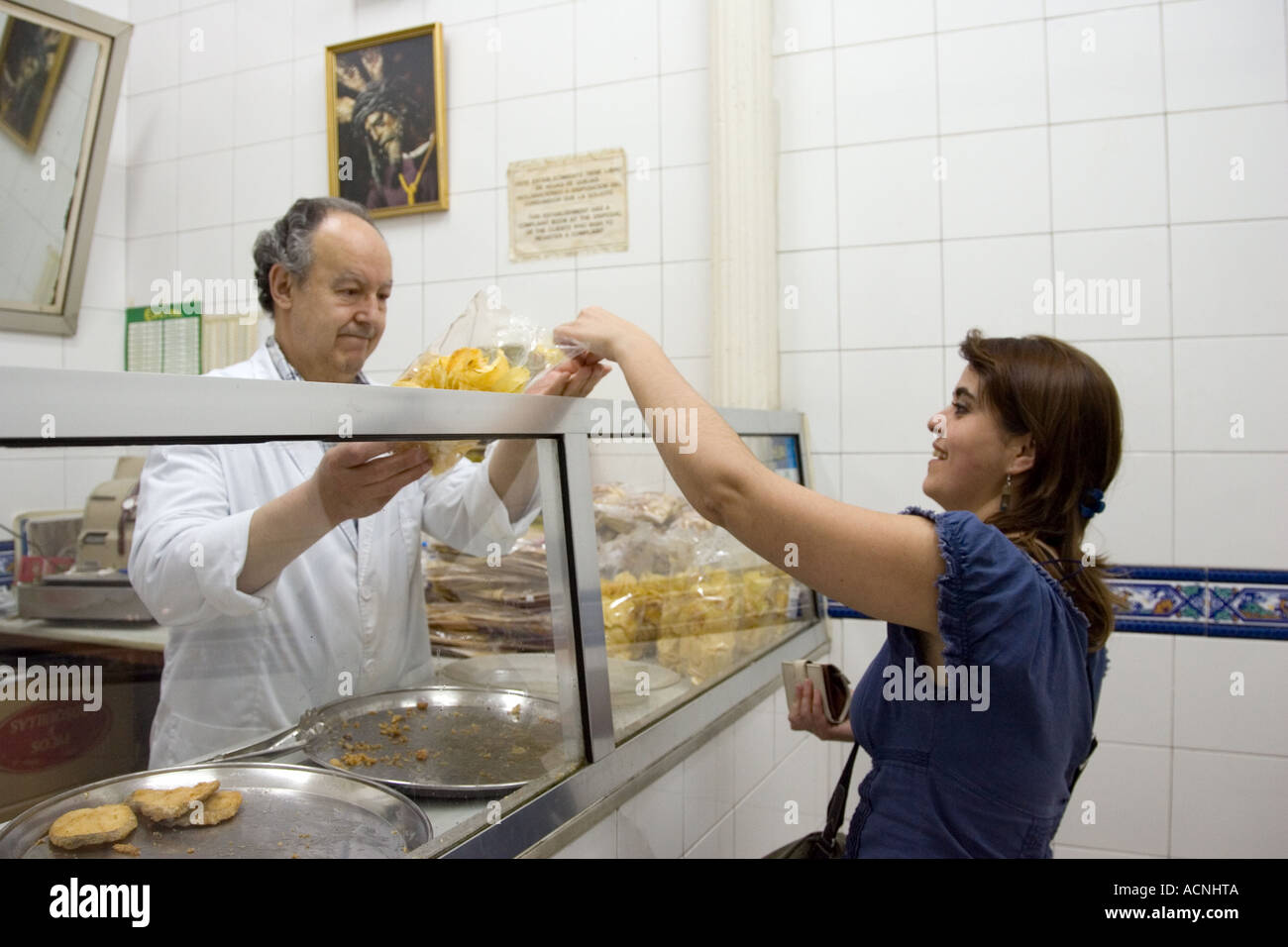 A girl purchasing potato chips in a traditional fried-fish shop ...