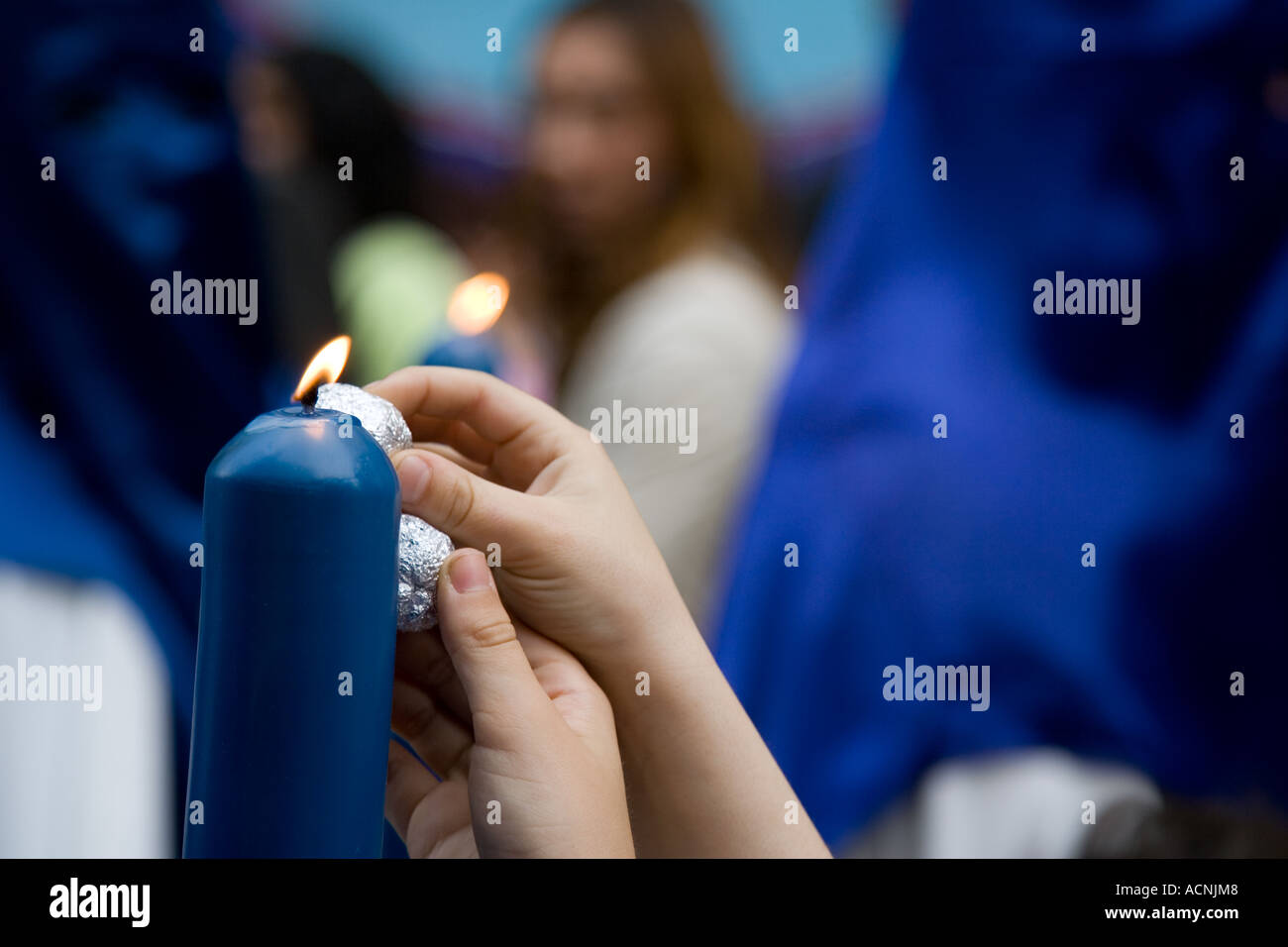 Children taking wax from a penitent's candle to make a ball, a typical ...