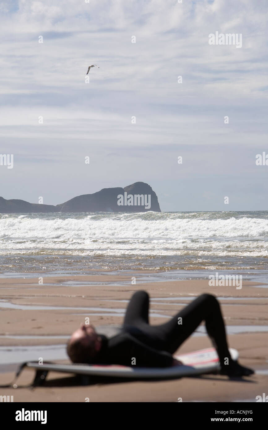 Surfer resting on his board on beach Stock Photo - Alamy