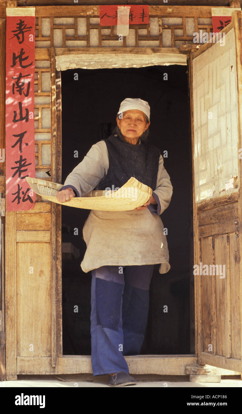 Hui woman by the doorway decorated with red poster of calligraphy ...
