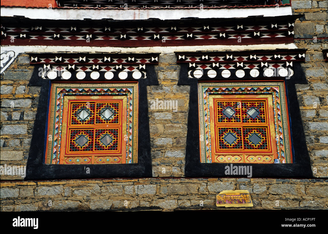 Tibetan architecture. Colorful windows in a granite stone house Stock ...