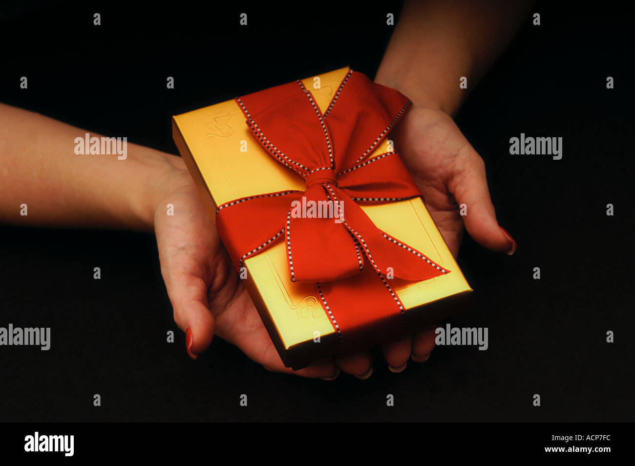 Womans hands holding a gift Stock Photo - Alamy