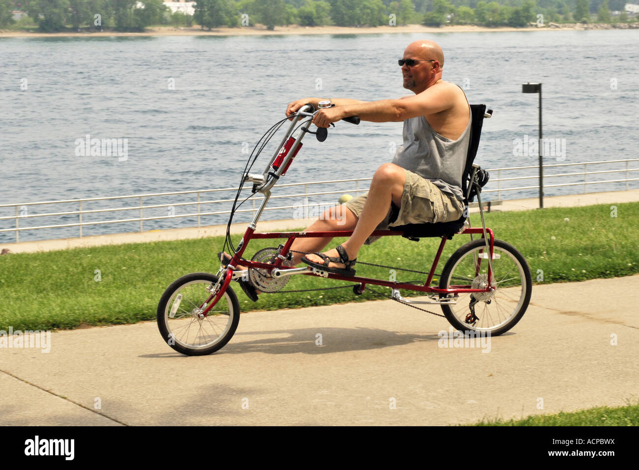 Adult male riding his recumbent bicycle along the waterfront in Port ...