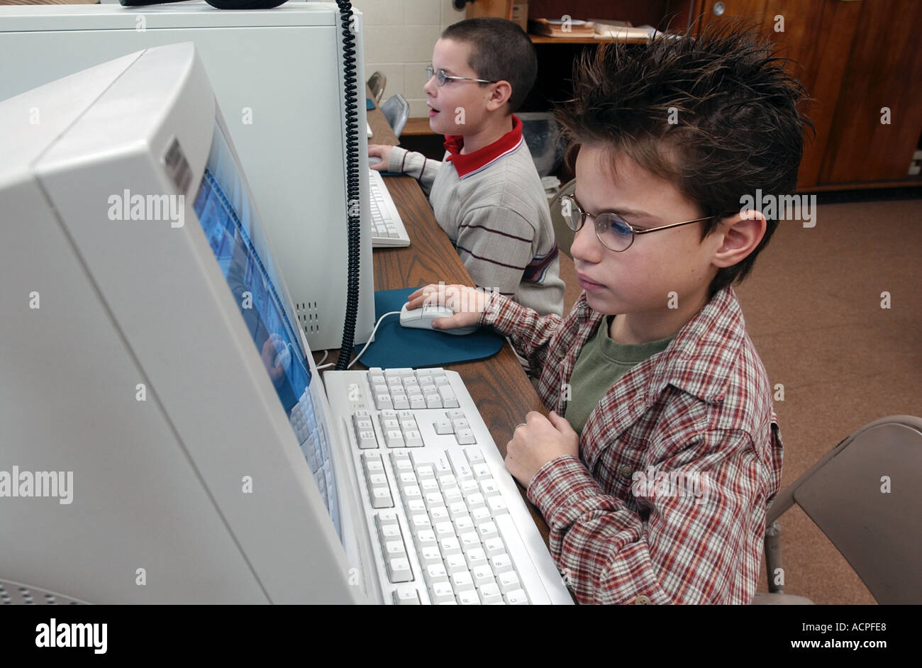 Boy child working on computer in school classroom learning computer ...