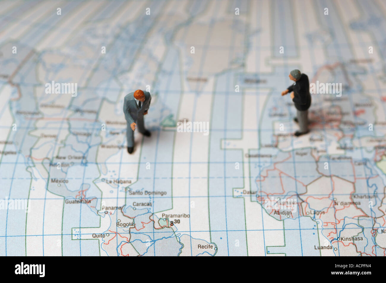 Two male figurines standing over map Stock Photo - Alamy