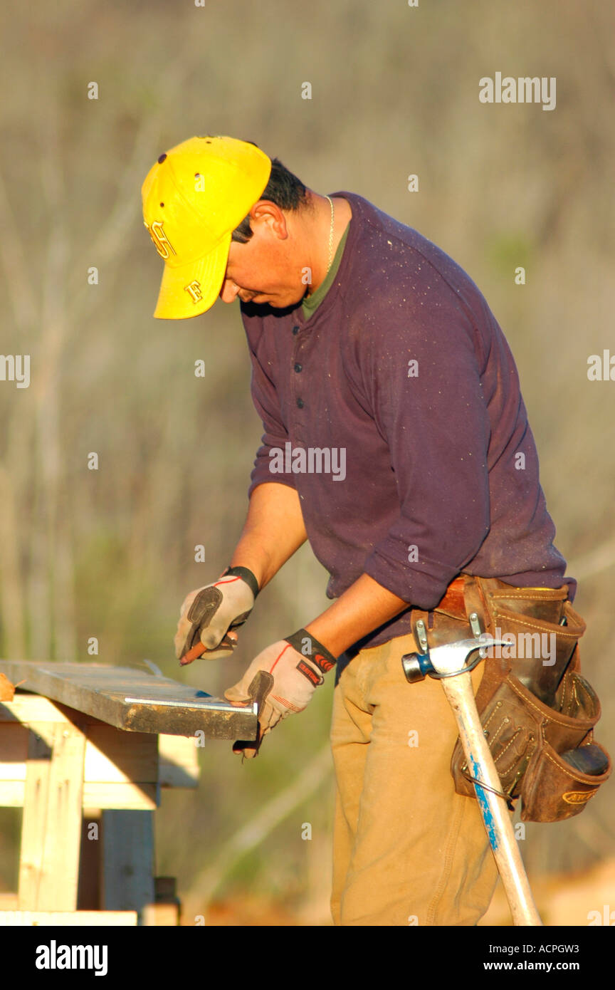 Hispanic Latin Mexican decking cutter on new home construction site ...