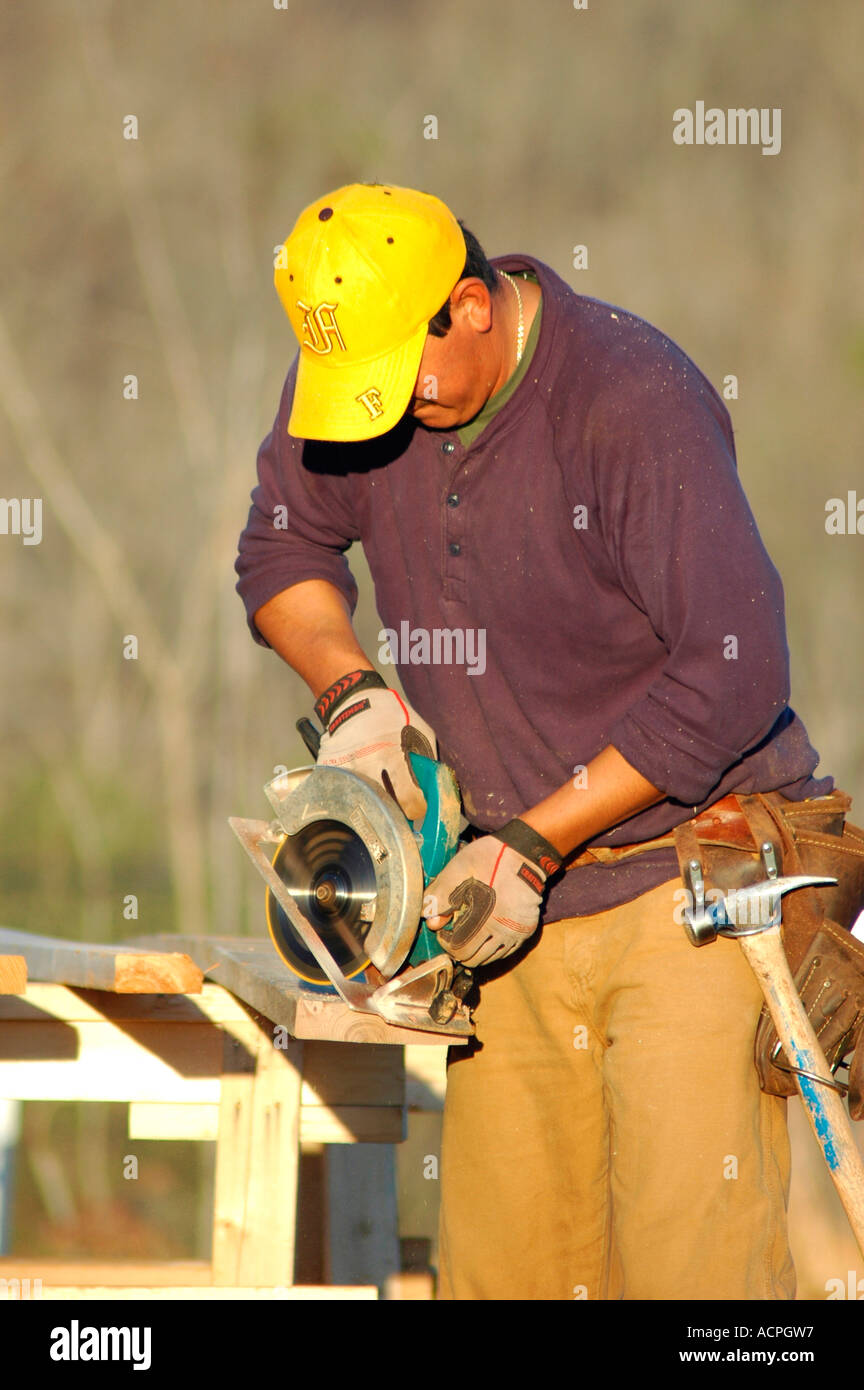 Hispanic Latin Mexican decking cutter on new home construction site ...