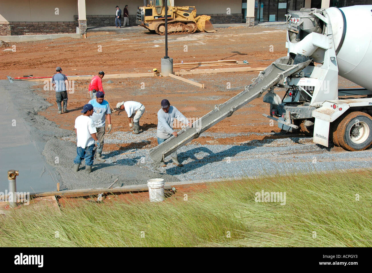 Pouring fresh cement from truck at real commercial business site being ...