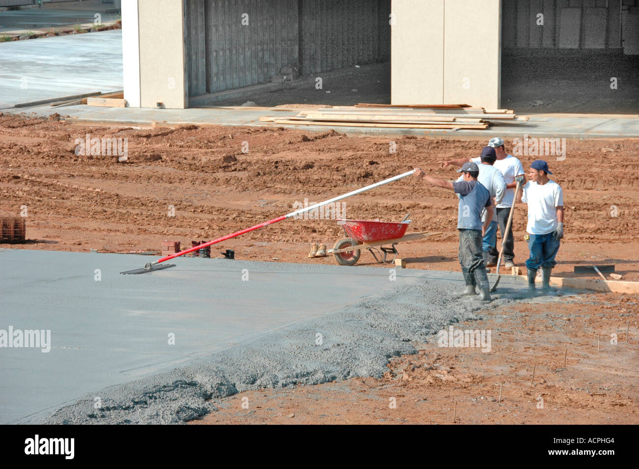 Pouring fresh cement from truck at real commercial business site being ...