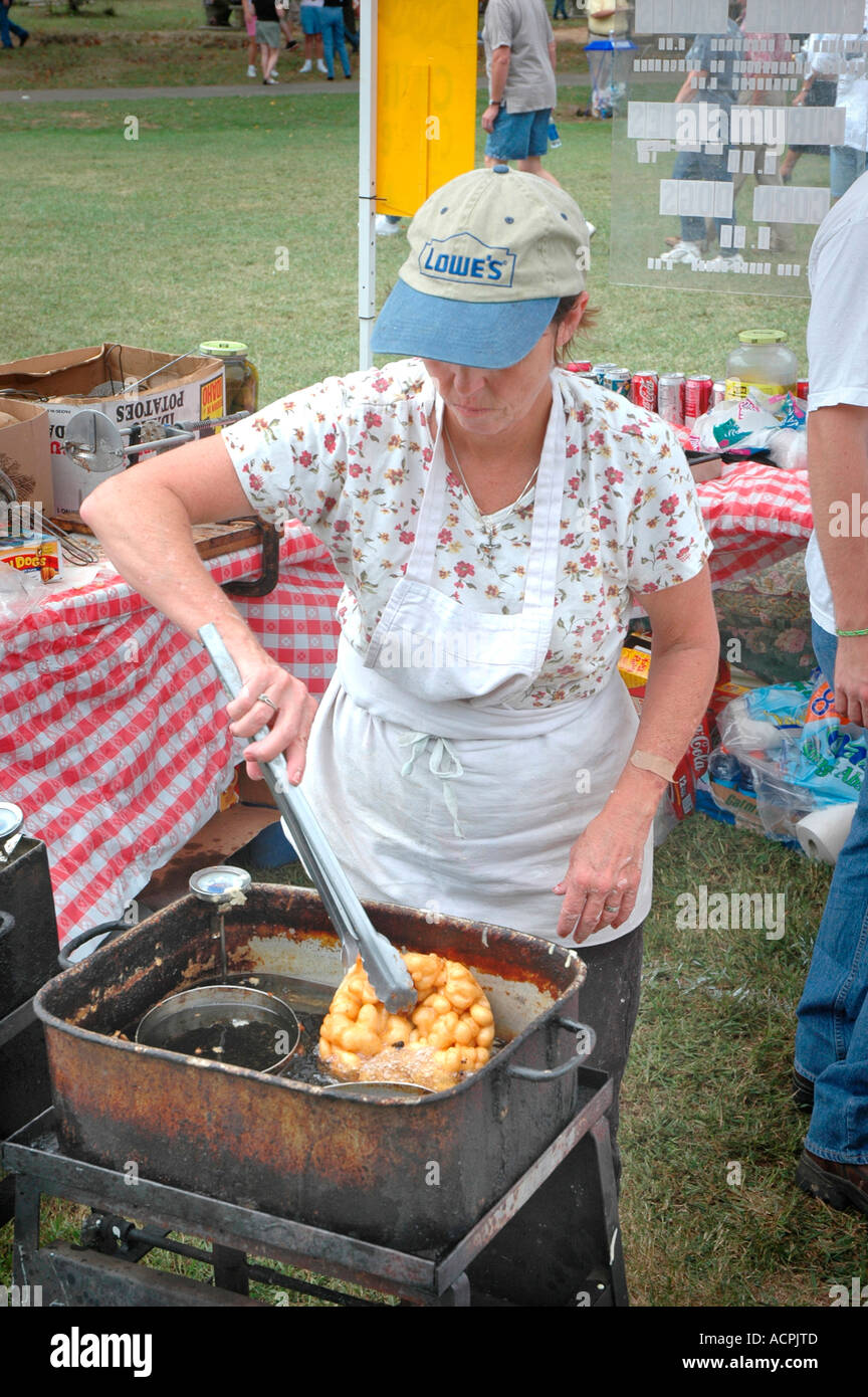 Deep frying fresh kettle cakes real funnel cakes for sale at fair in ...