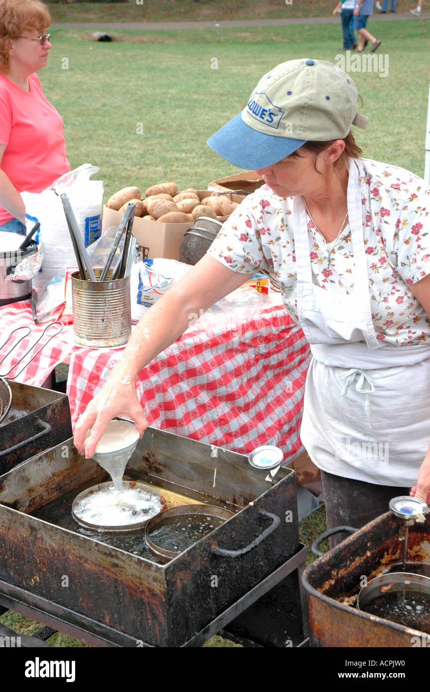 Deep frying fresh kettle cakes real funnel cakes for sale at fair in ...