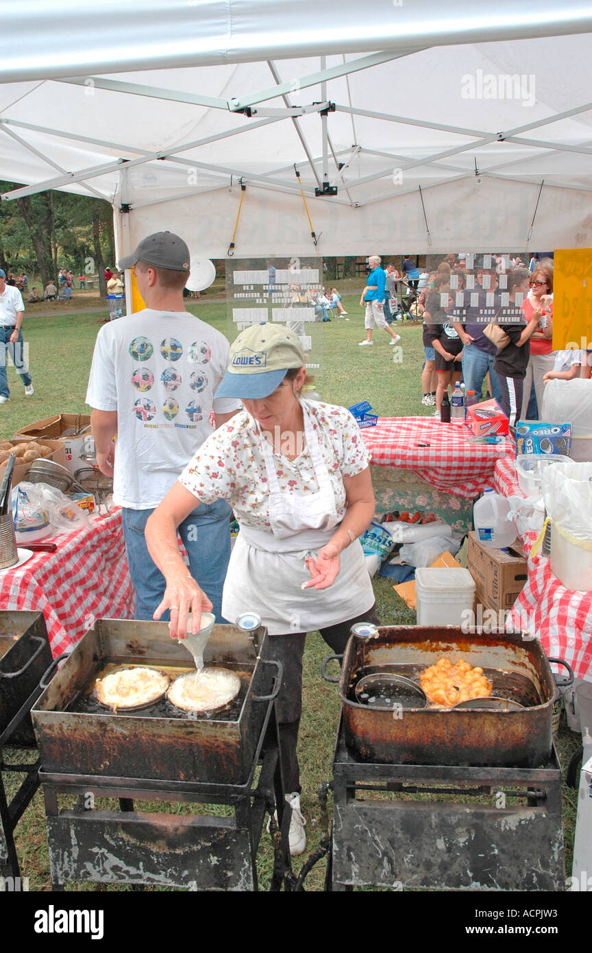 Deep frying fresh kettle cakes real funnel cakes for sale at fair in ...