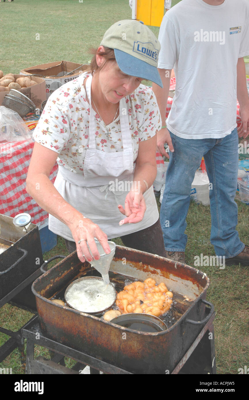 Deep frying fresh kettle cakes real funnel cakes for sale at fair in ...