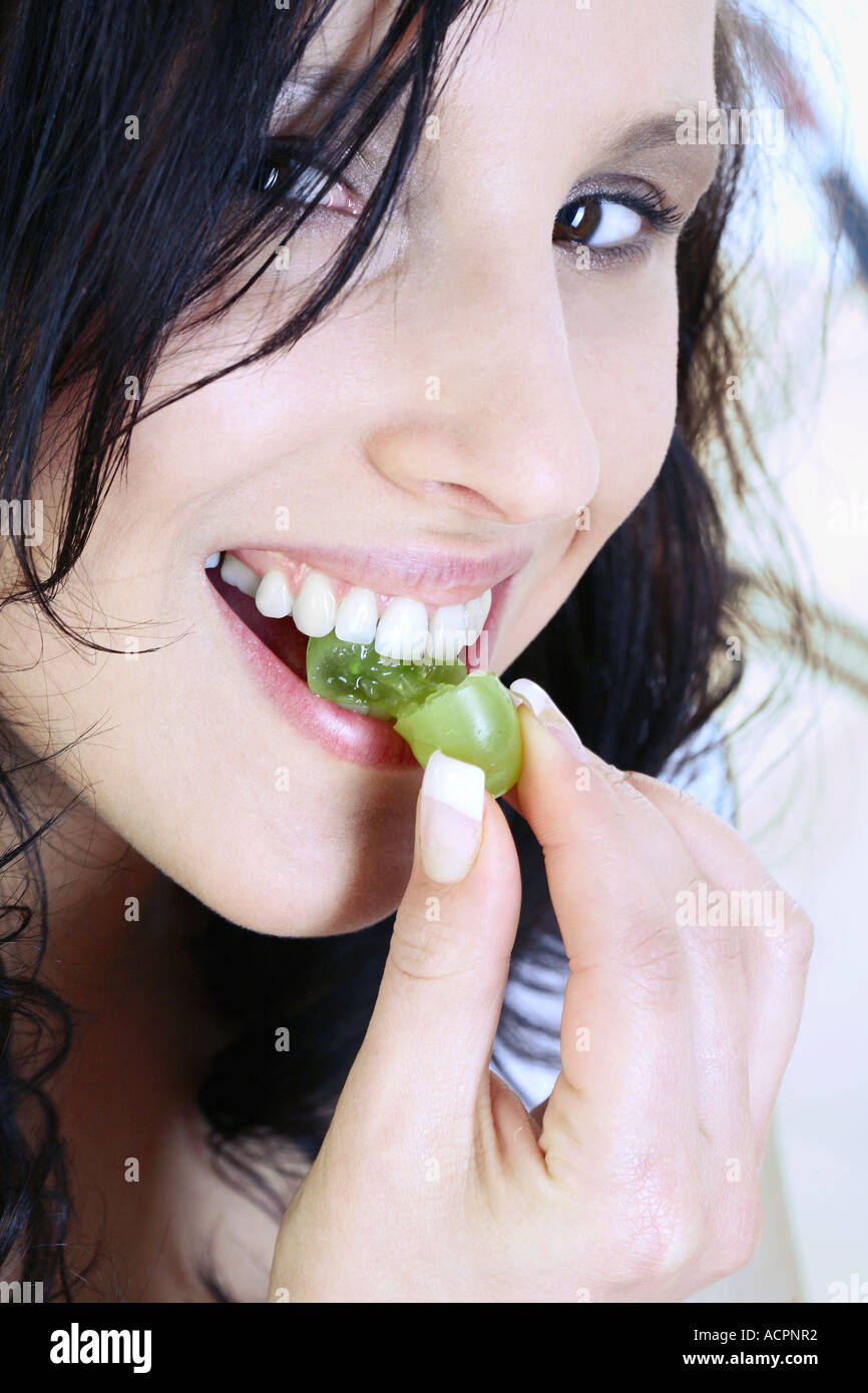 Young woman eating grape Stock Photo - Alamy