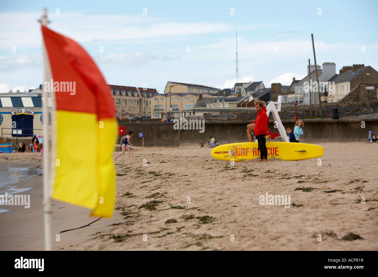 red and yellow beach patrol flag flying on pole with lifeguards ...