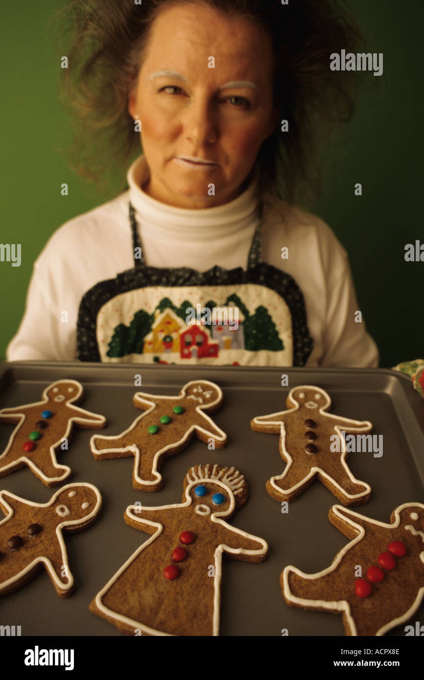 Lady with mad exhausted look on face holding gingerbread cookie sheet ...
