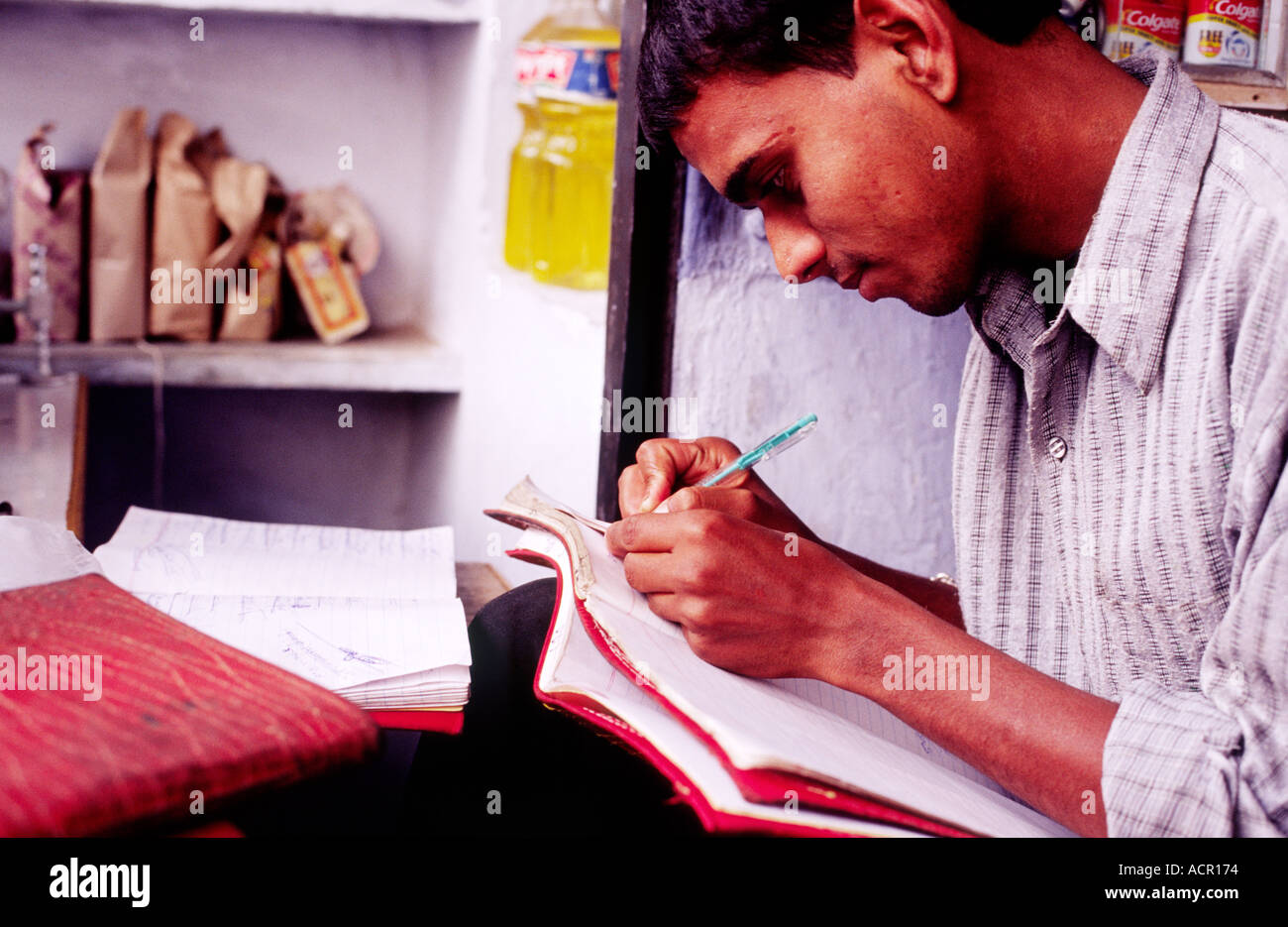 Young Indian male writing in a notebook Stock Photo - Alamy