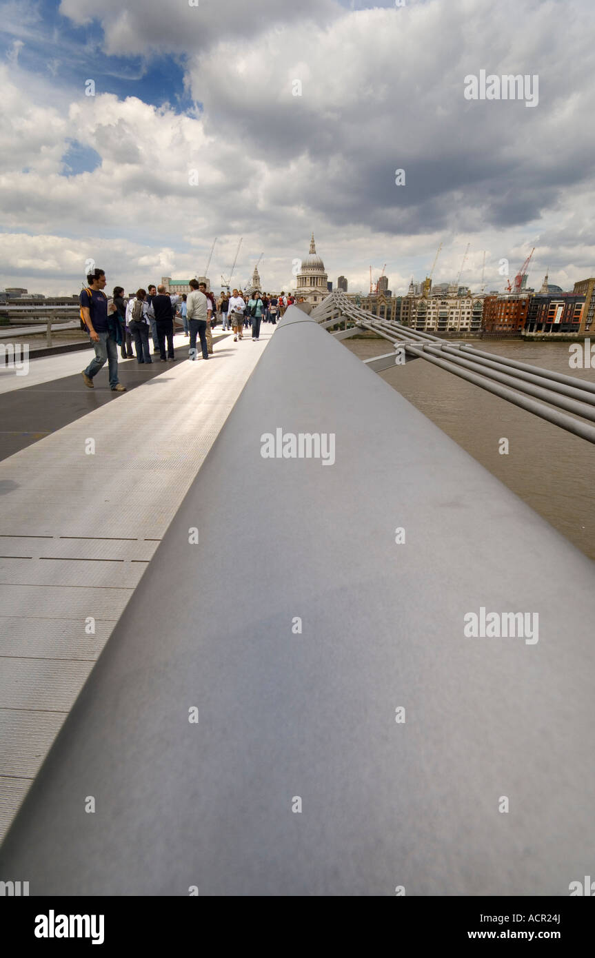 People walking on the millenium bridge over the river thames in London ...
