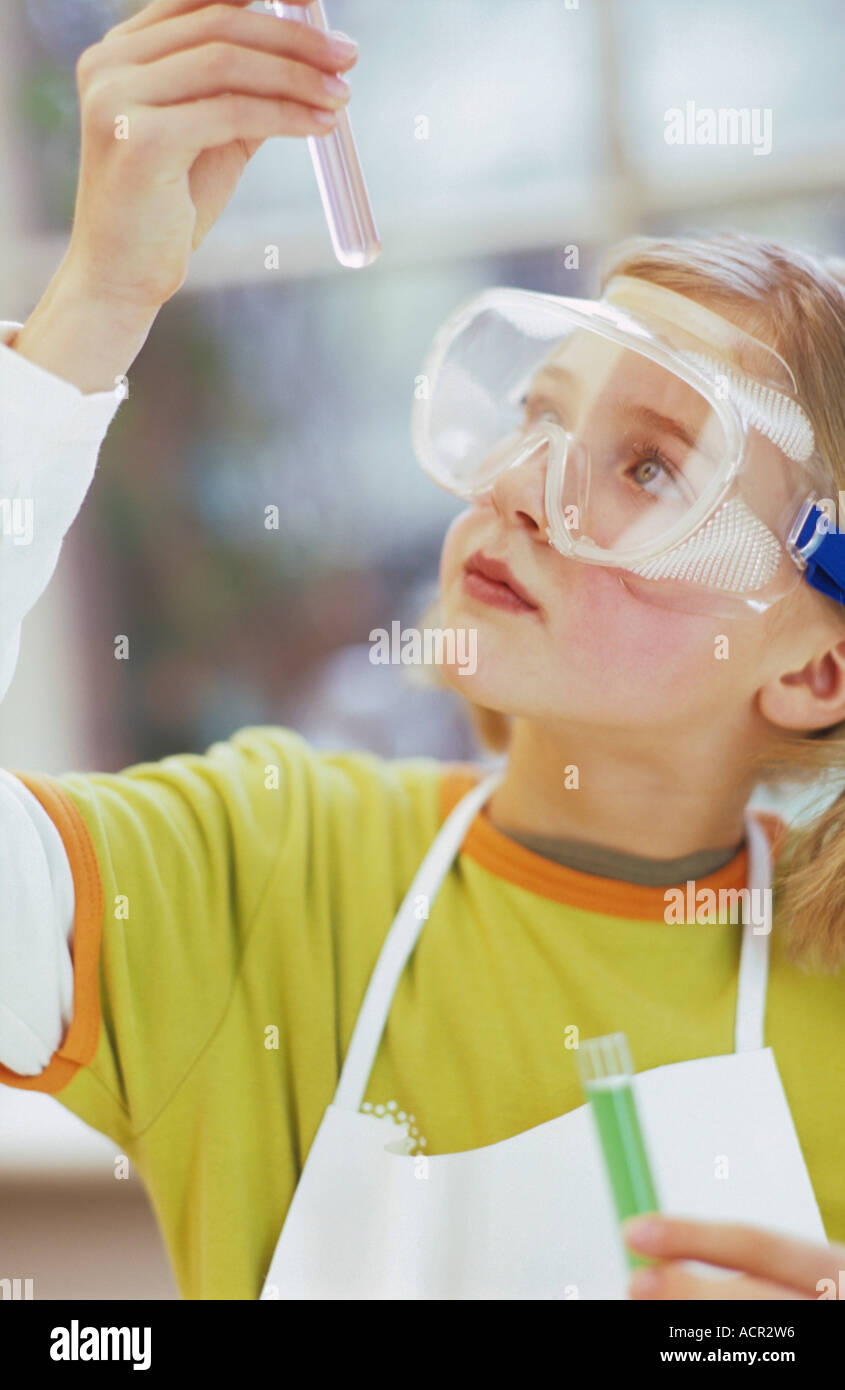Girl (8-9) wearing protective goggles with test tube Stock Photo - Alamy